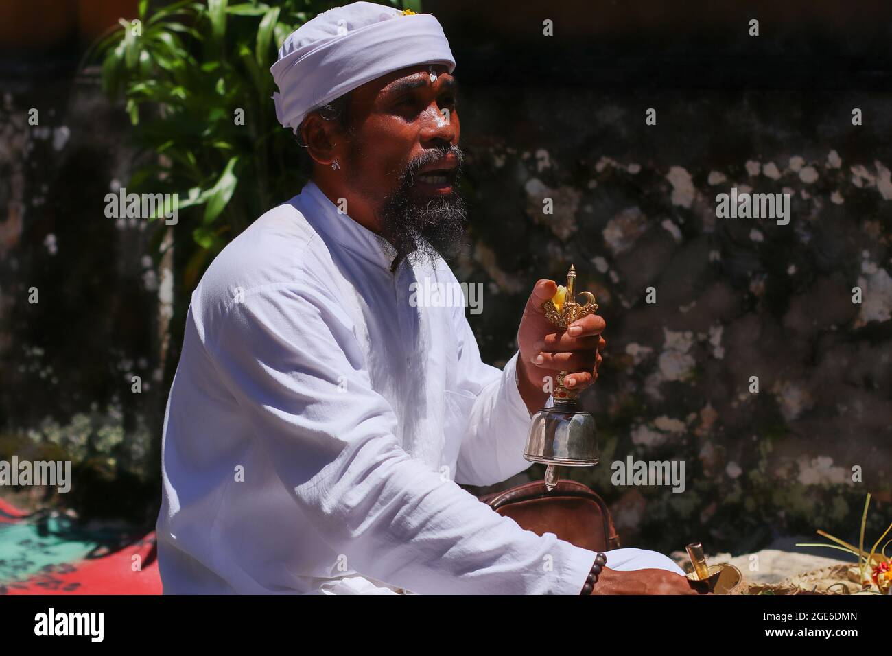Close up of a Balinese pedanda during prayer. side view of a hindu ...