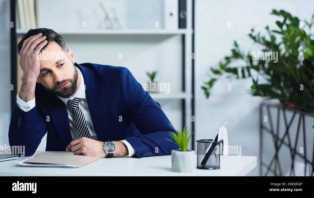 sad businessman in suit sitting in office Stock Photo - Alamy