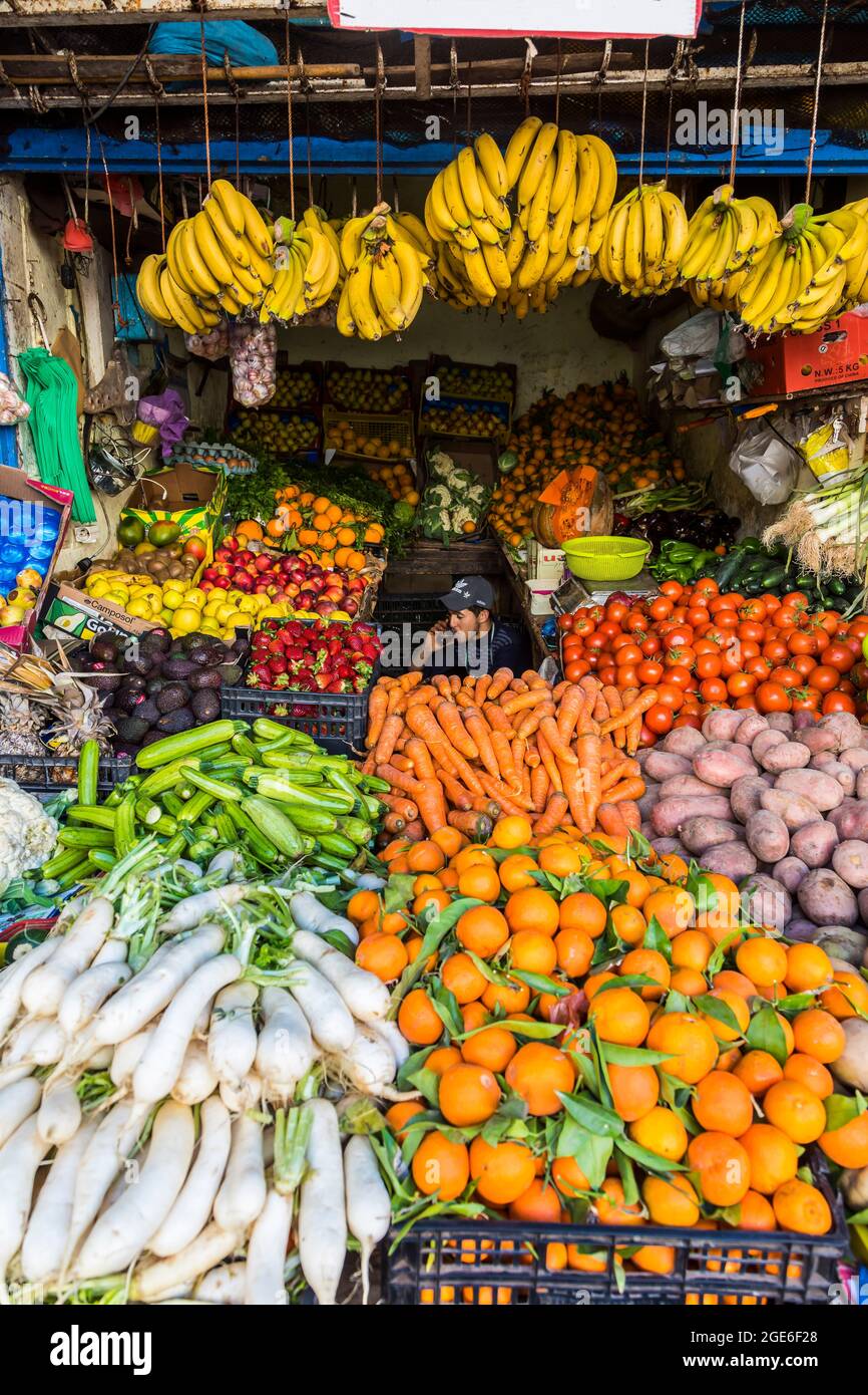 Morocco, Essaouira: shop of a fruit and vegetable seller. Seller amid a ...