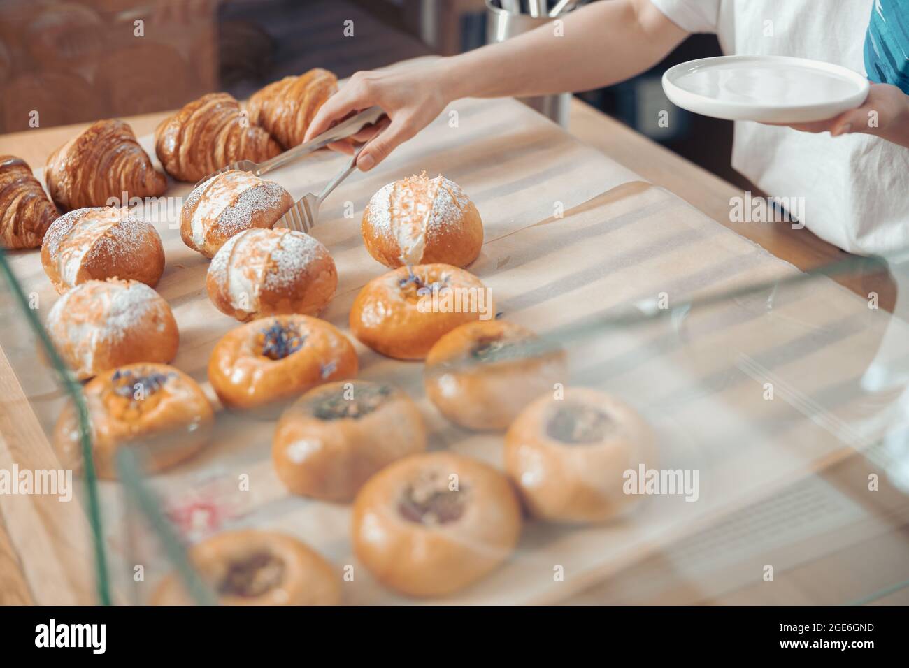 Female hand taking pastry from showcase in cafeteria Stock Photo - Alamy