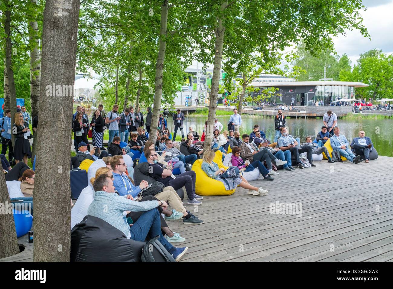 Participants sitting on bean bags during outdoor conference Stock Photo ...