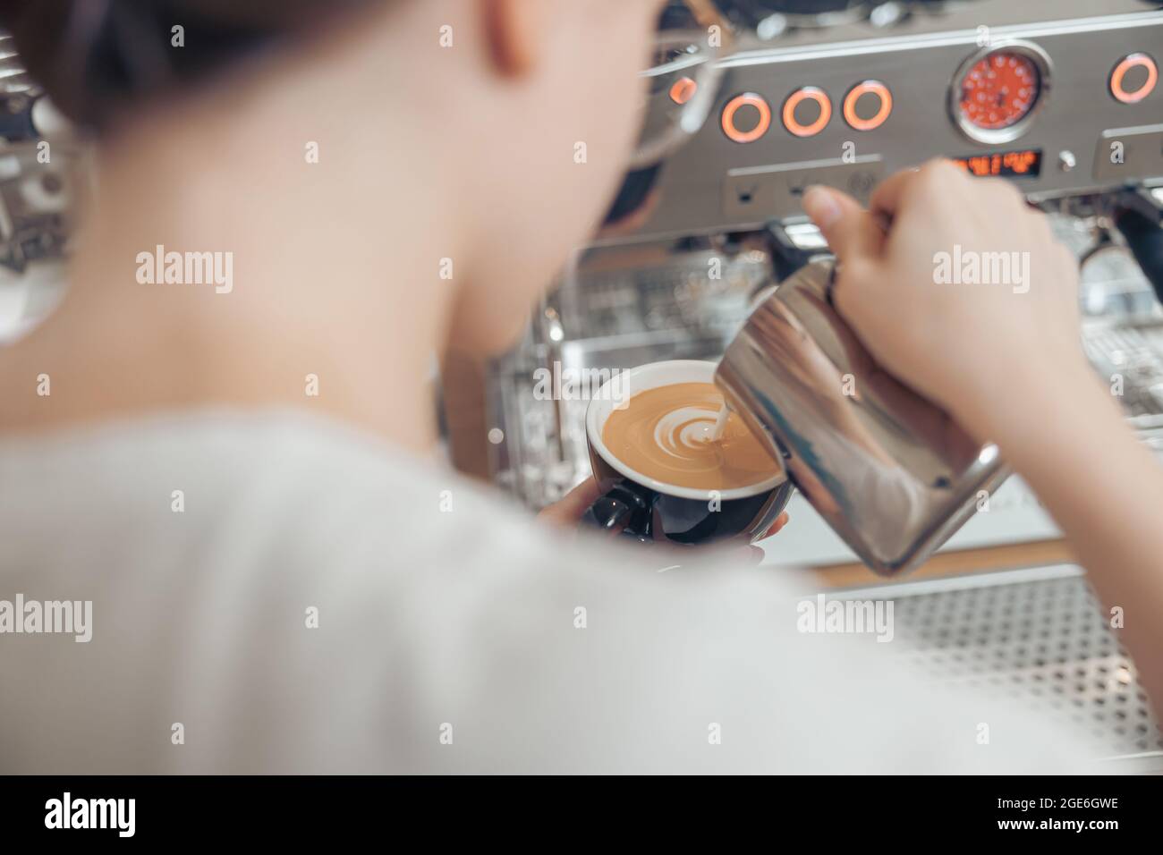 Female barista making latte art in coffee shop Stock Photo - Alamy