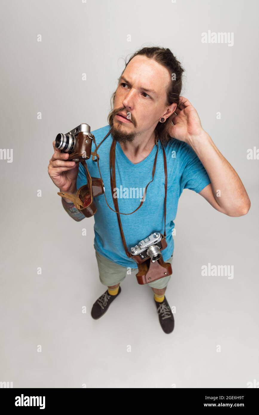 High angle view of young man, photographer, cameraman with retro camera ...