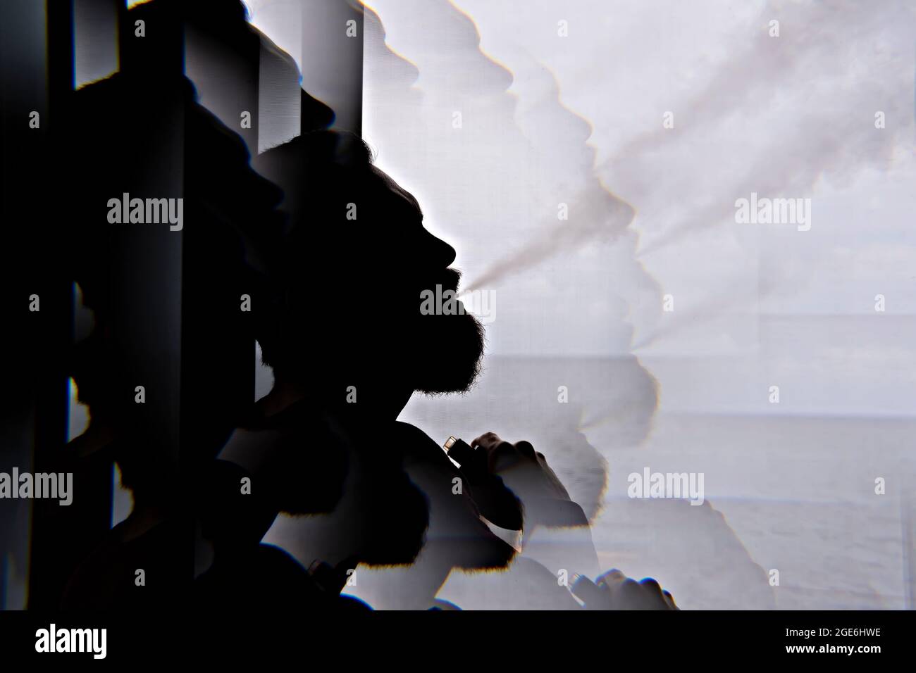 Silhouette of vaper man with cloud of vapor. EVALI stands for e ...