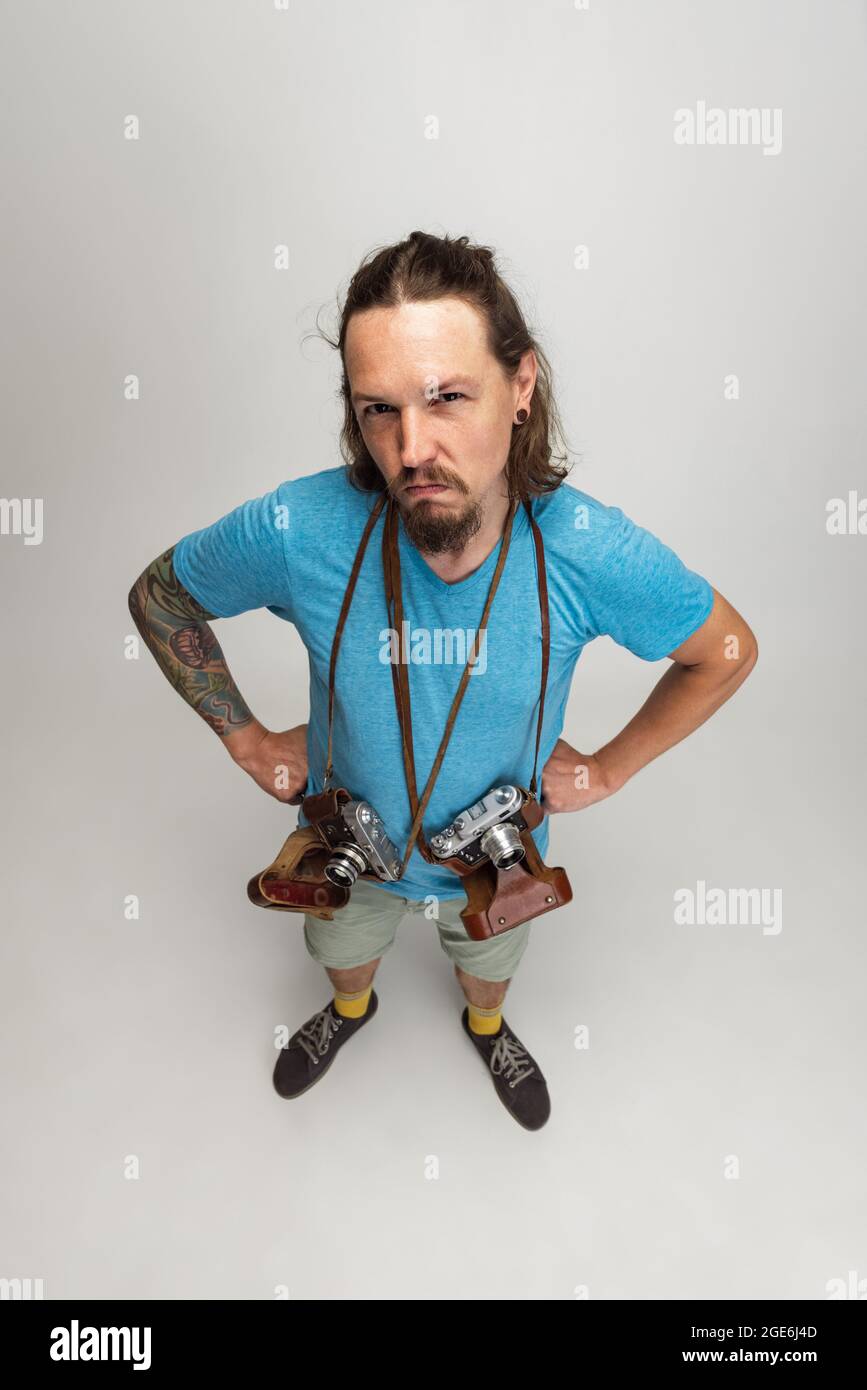 High angle view of young man, photographer, cameraman with retro camera ...