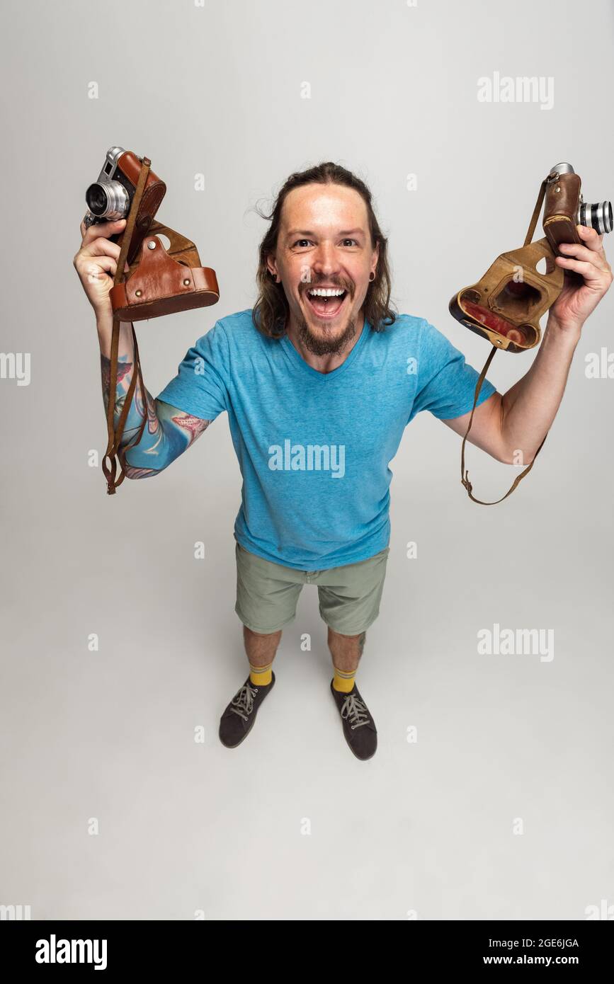 High angle view of young man, photographer, cameraman with retro camera ...