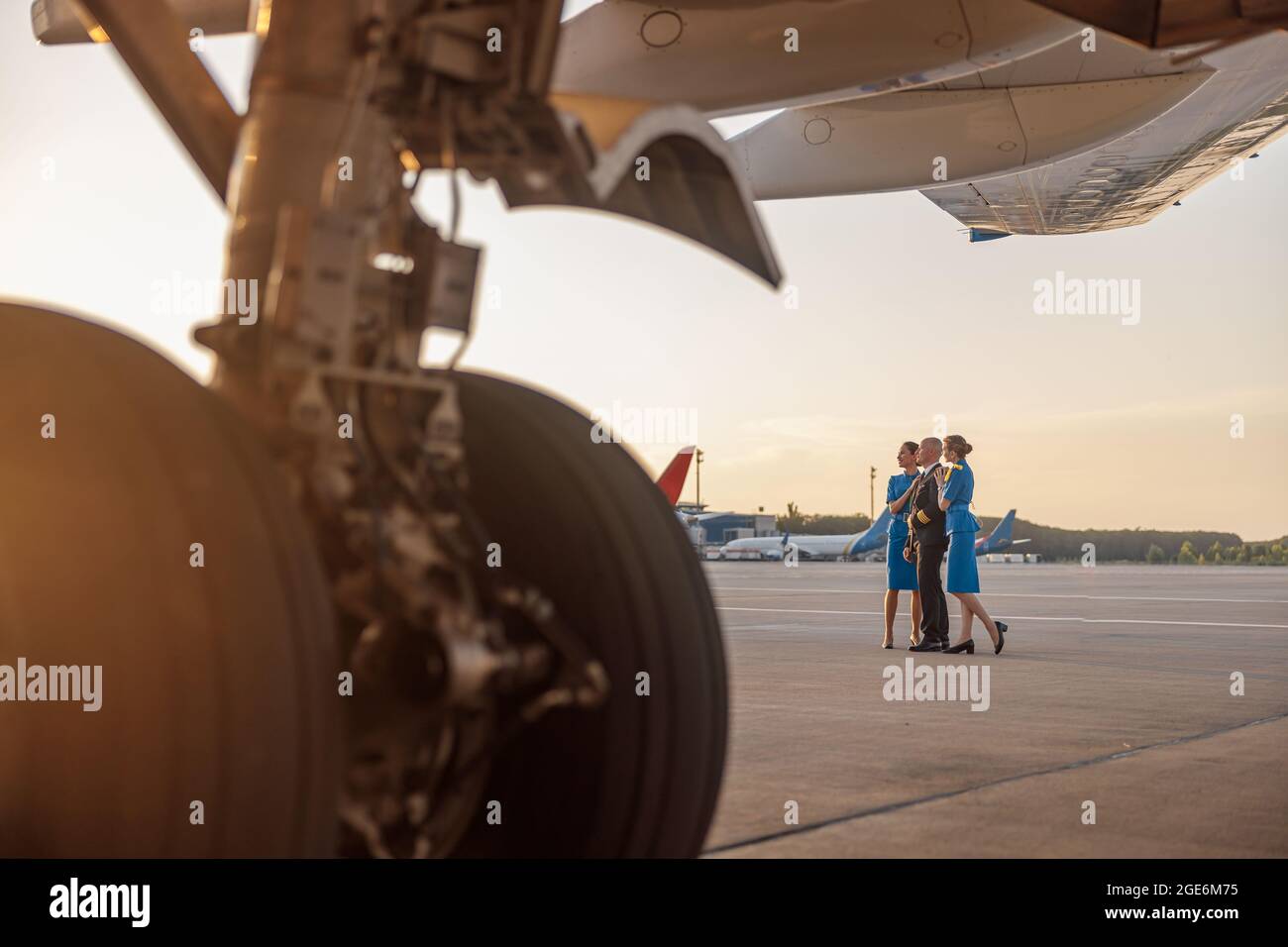 Full length shot of male pilot posing for photoshoot together with two ...