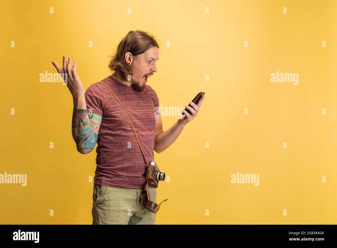 Portrait of young man, photographer, cameraman with retro camera using ...