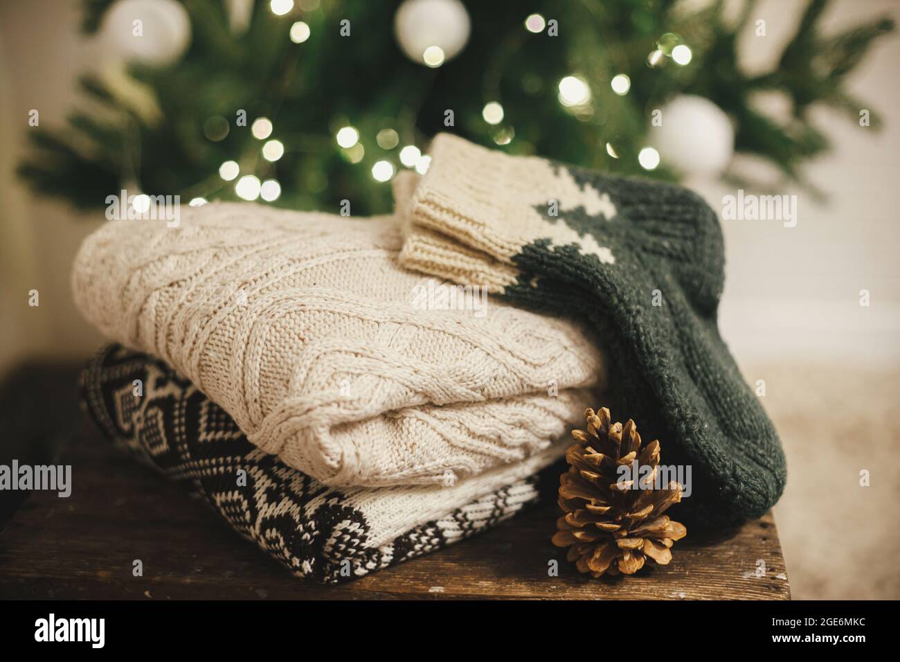 Cozy knitted sweaters and wool socks on rustic wood with pine cone on ...