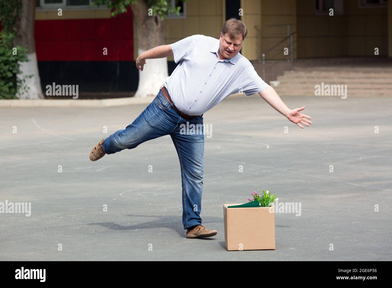 An angry man kicks his box of personal belongings after being fired ...