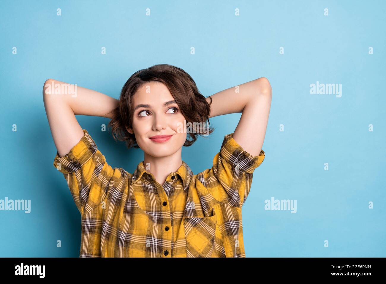 Photo of positive curious lady hands behind head look empty space wear ...