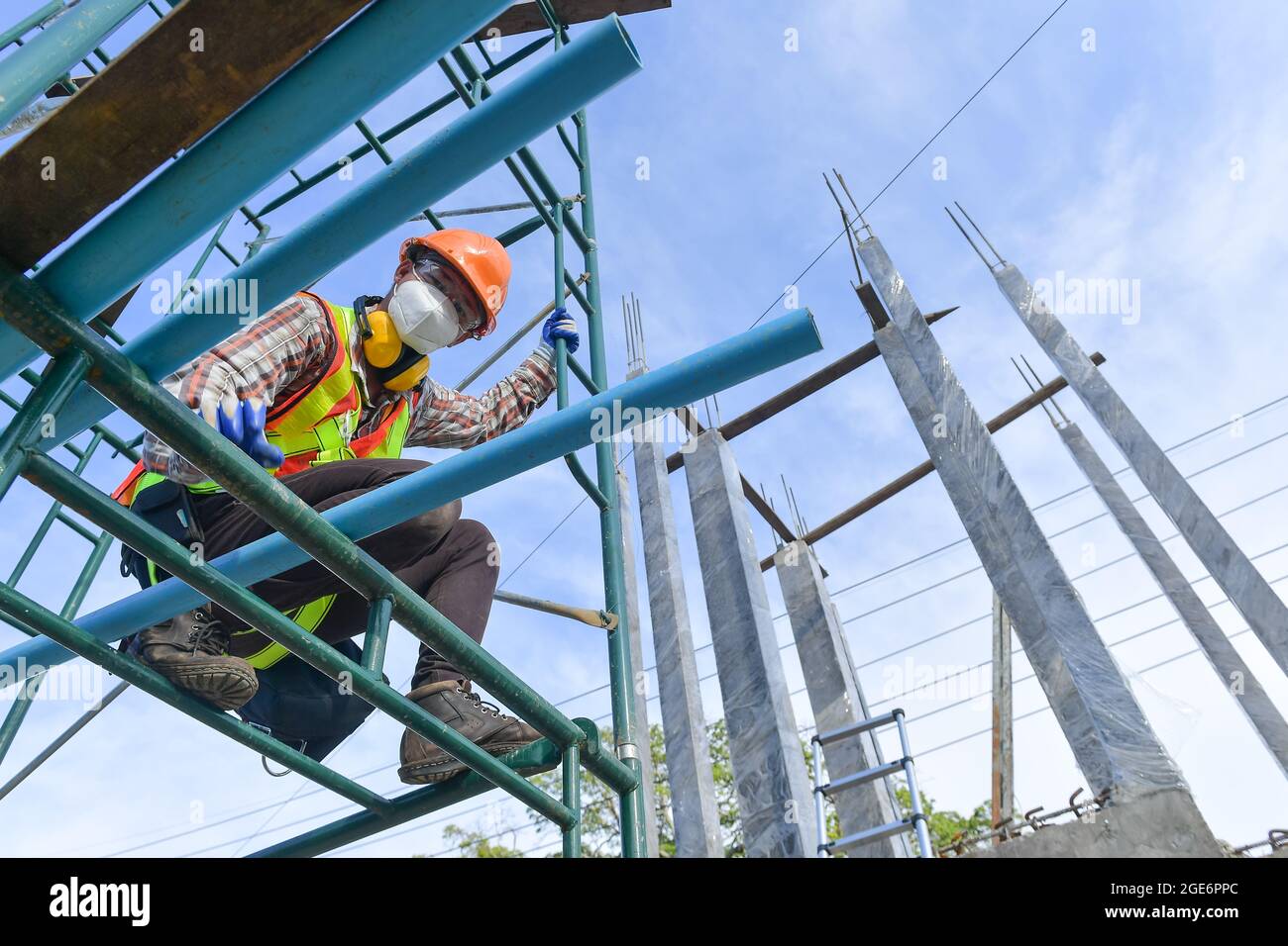 Construction worker wearing safety work at high uniform on scaffolding ...