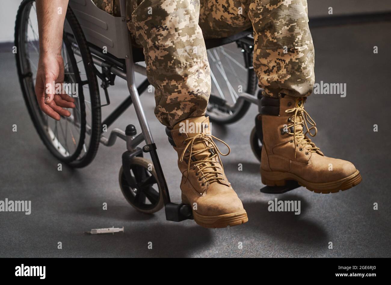 Disabled military man sitting in a wheelchair and cannot reach a fallen ...
