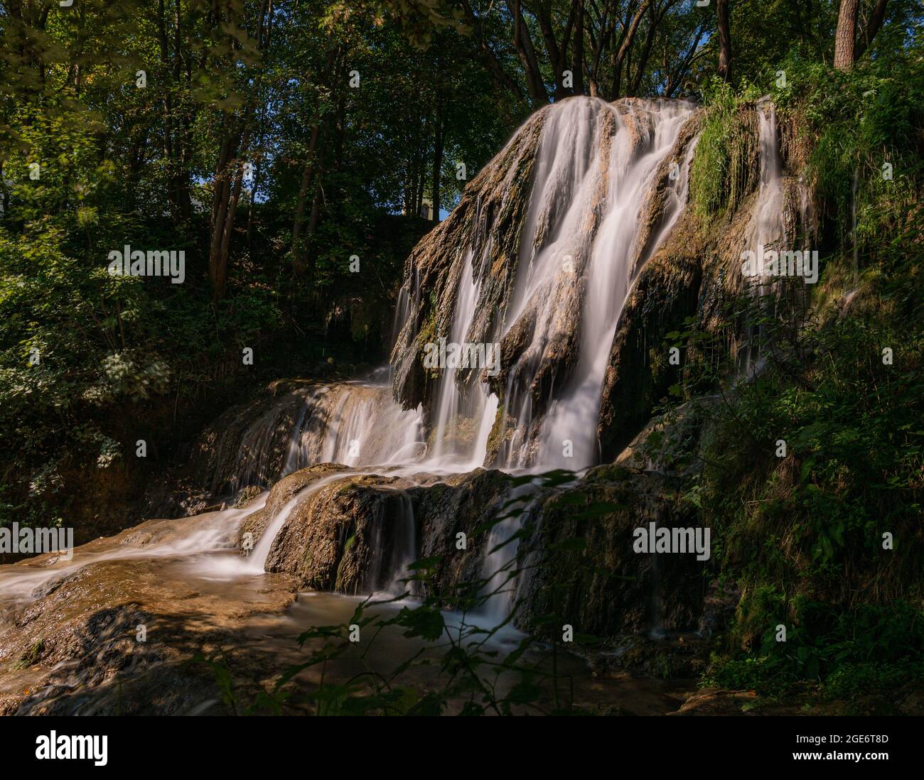 A very beautiful waterfall in a small clearing in the forest Stock ...