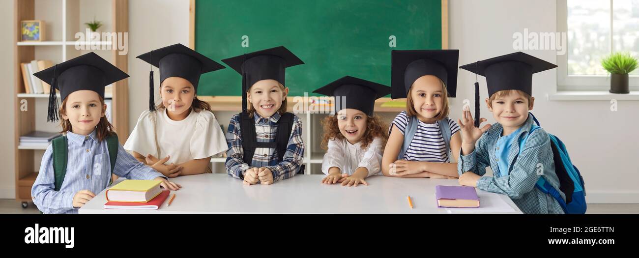 Banner with group of happy school kids in academic caps standing by ...