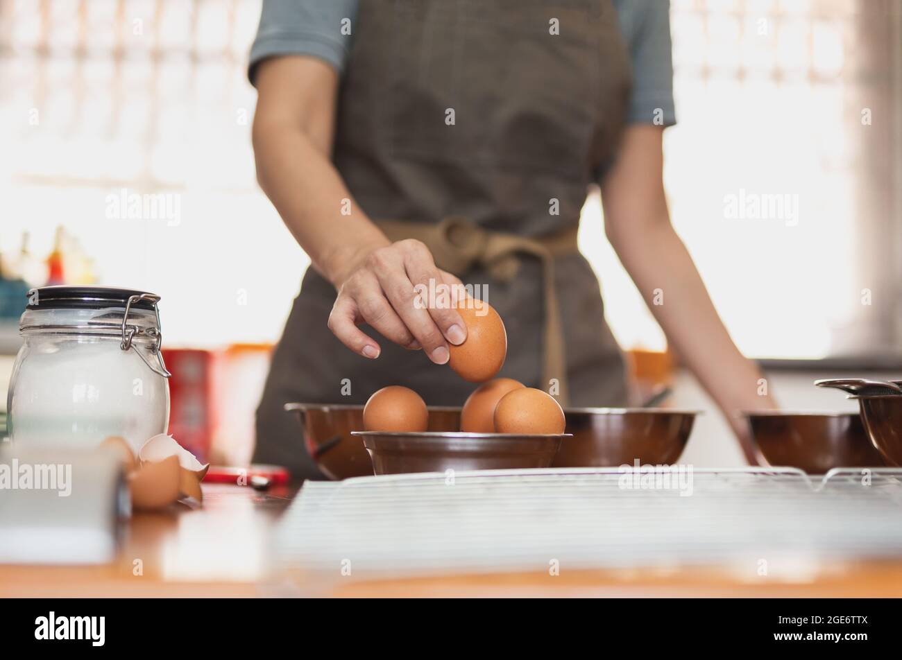 Woman chef pick up fresh raw egg preparing ingredient for making ...