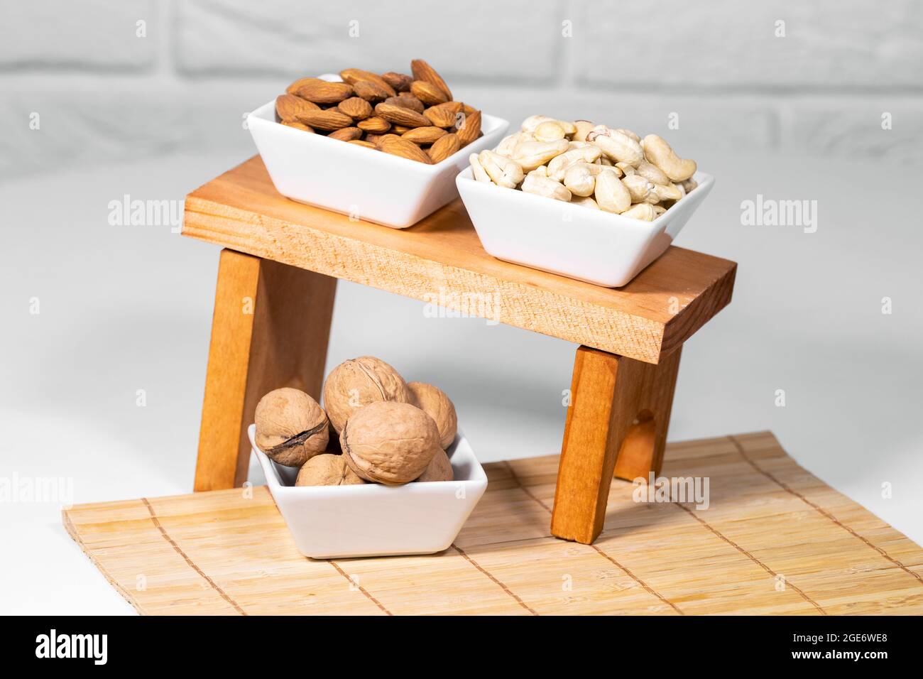 Mix of Nuts, Almond, Cashew, Wallnut in white ceramic bowls on wooden ...