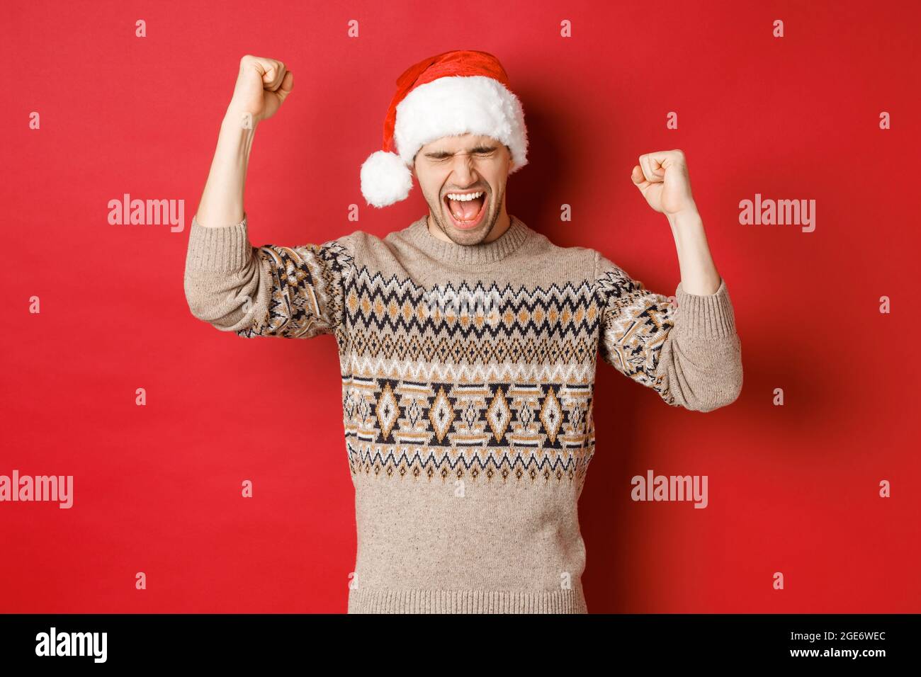 Satisfied handsome man, feeling lucky and happy, shouting for joy and ...