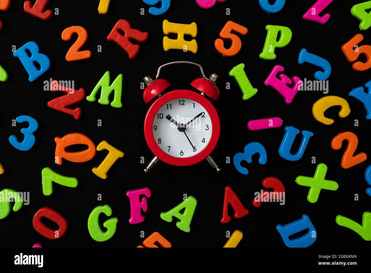 Alarm clock and letters and symbols of the alphabet on a black ...