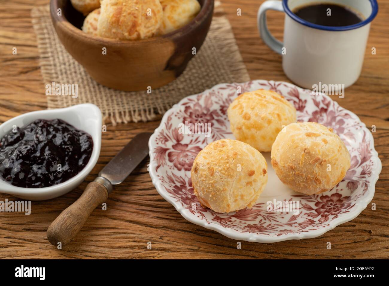 Typical brazilian cheese bun in a basket, coffee and jam Stock Photo - Alamy