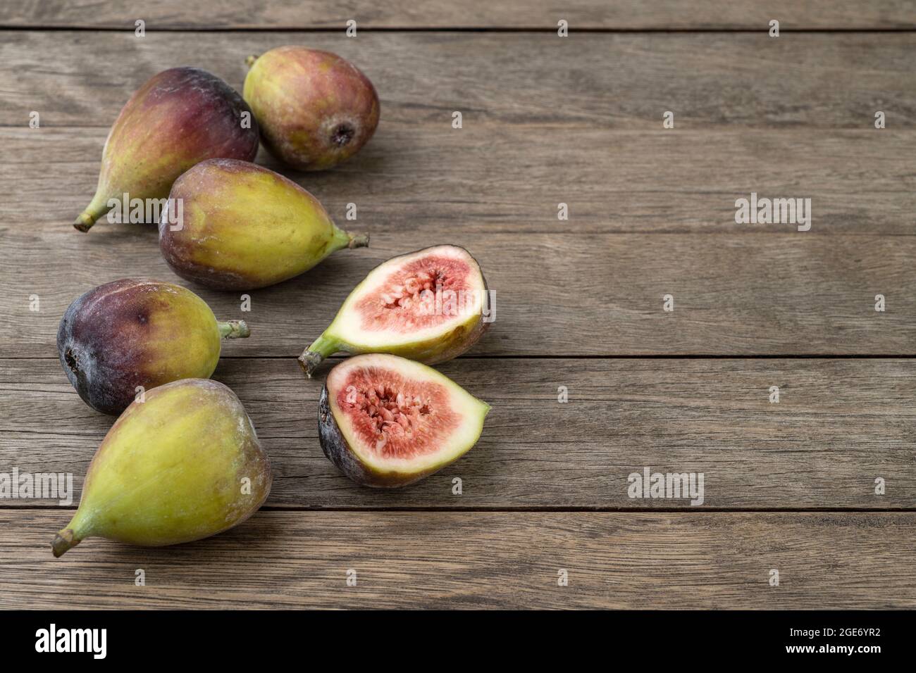 Figs with cut fruit over wooden table with copy space Stock Photo - Alamy