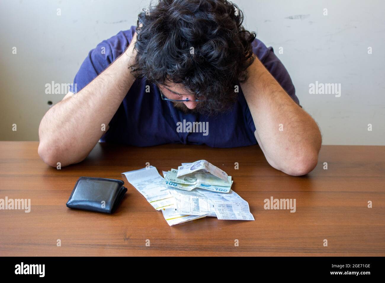 Man with various bills in front of him. A man who cannot pay his debts ...