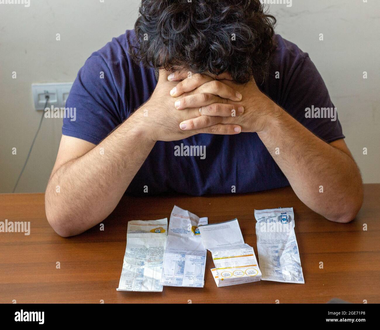 Man with various bills in front of him. A man who cannot pay his debts ...