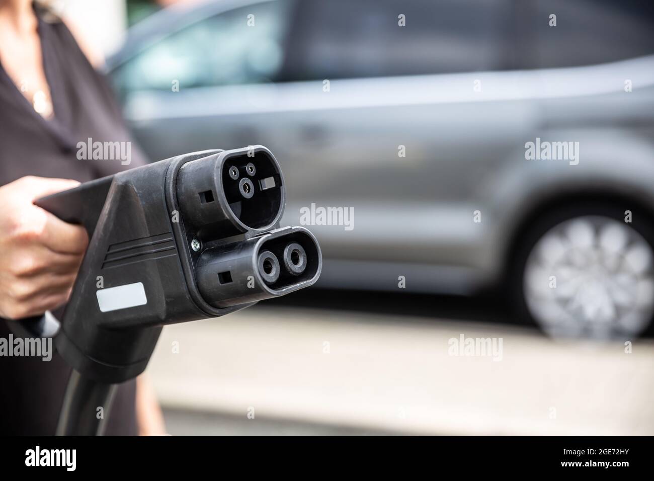 Hand holding ev plug hi-res stock photography and images - Alamy