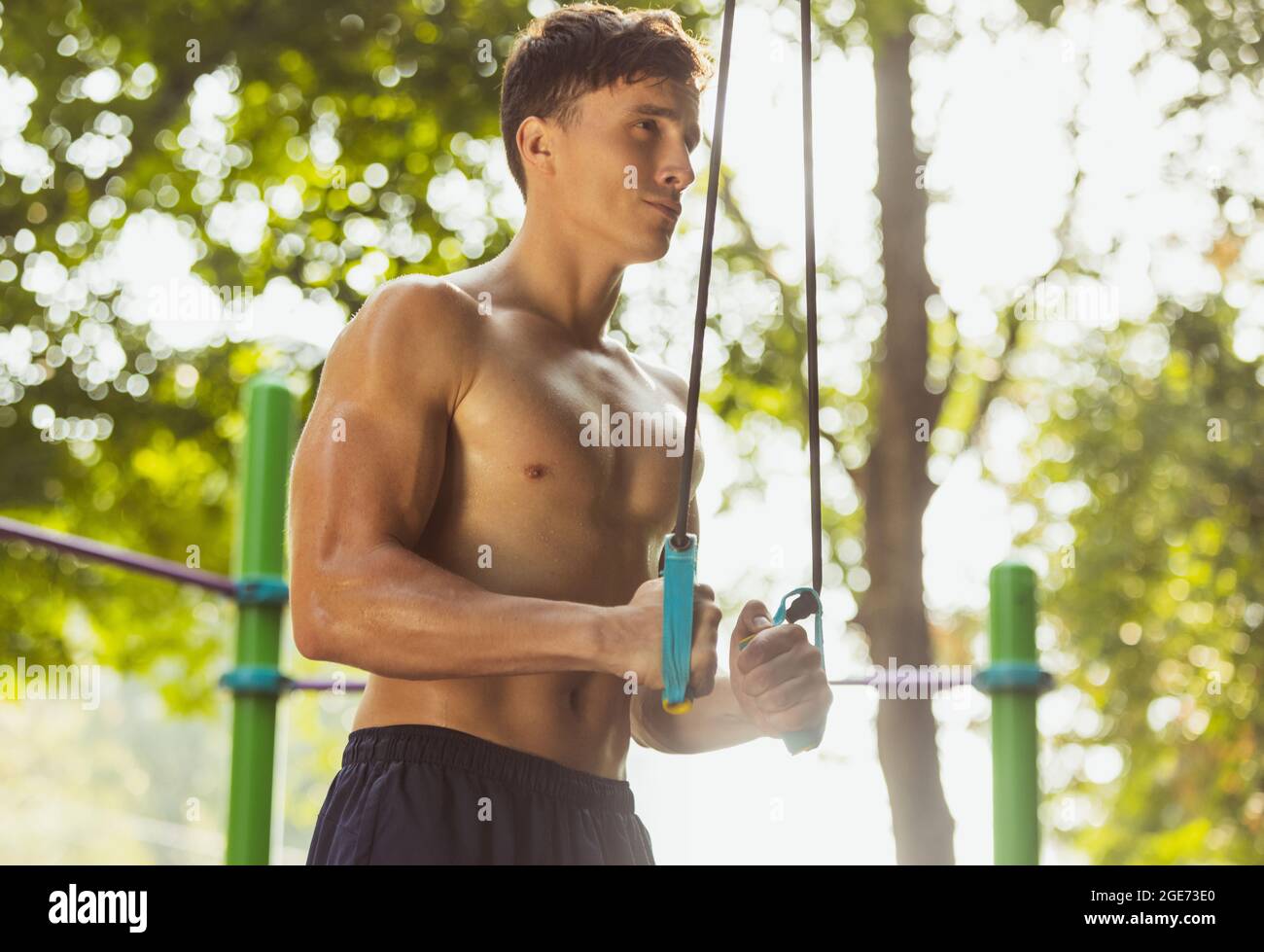 One young handsome caucasian man doing exercises for biceps and triceps ...