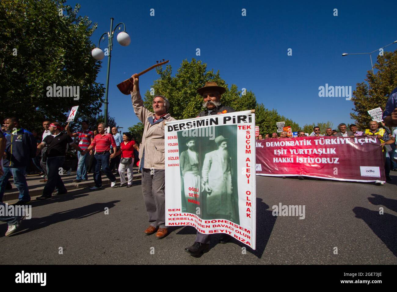 Two demonstrators holding a saz, musical instrument traditionally used ...