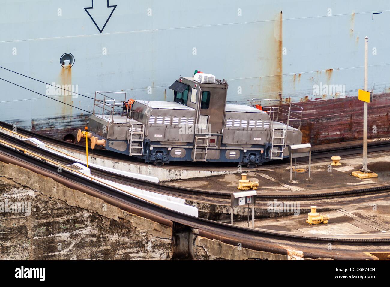 Electric locomotive, known as mule, guiding a container ship through ...
