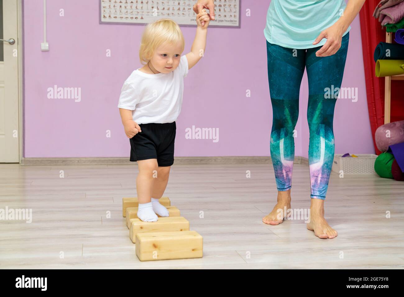Mom and baby are doing developmental exercises in the gym ...