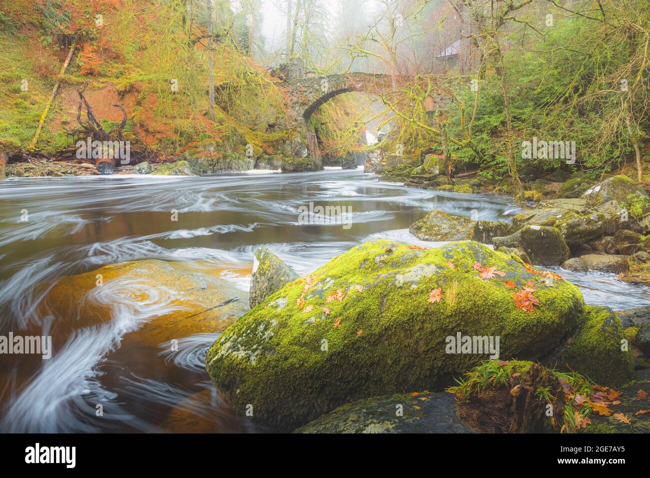 Old Roman stone bridge over flowing water of the River Braan at the ...