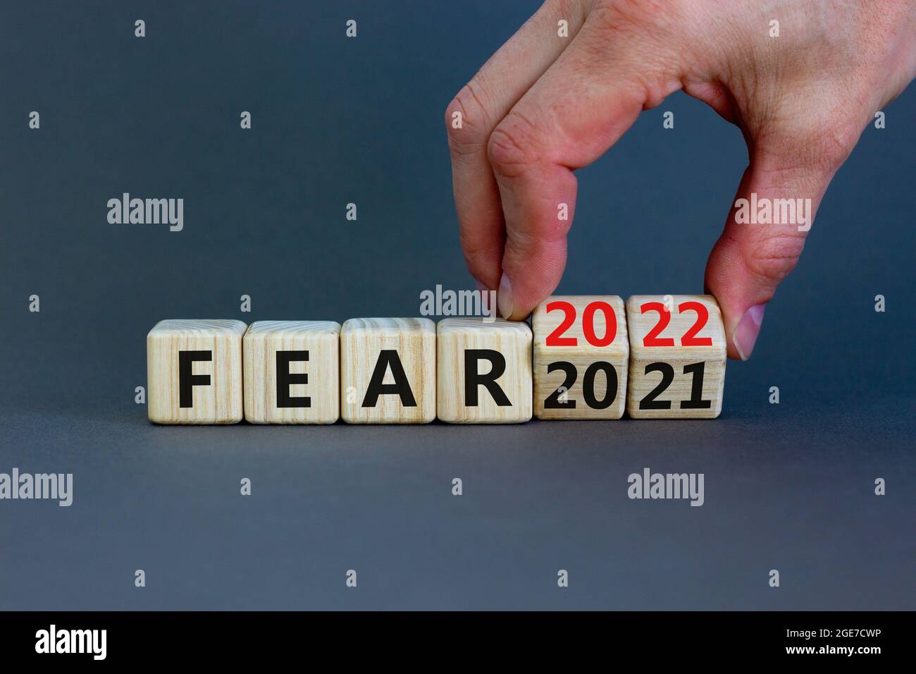 2022 fear new year symbol. Businessman turns a wooden cube and changes words 'Fear 2021' to ...
