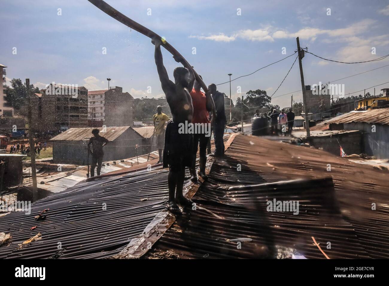 Nairobi, Kenya. 17th Aug, 2021. Residents climb rooftops to help put ...