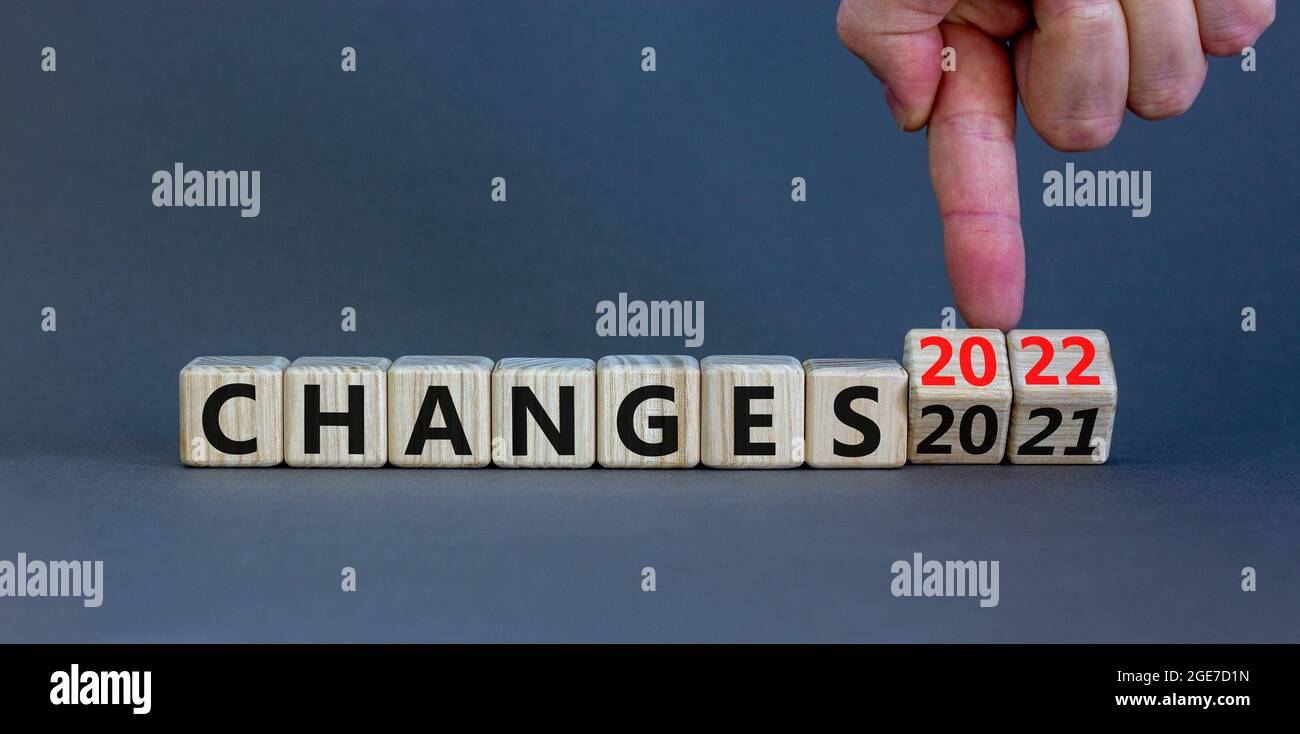 Planning 2022 changes new year symbol. Businessman turns a wooden cube ...