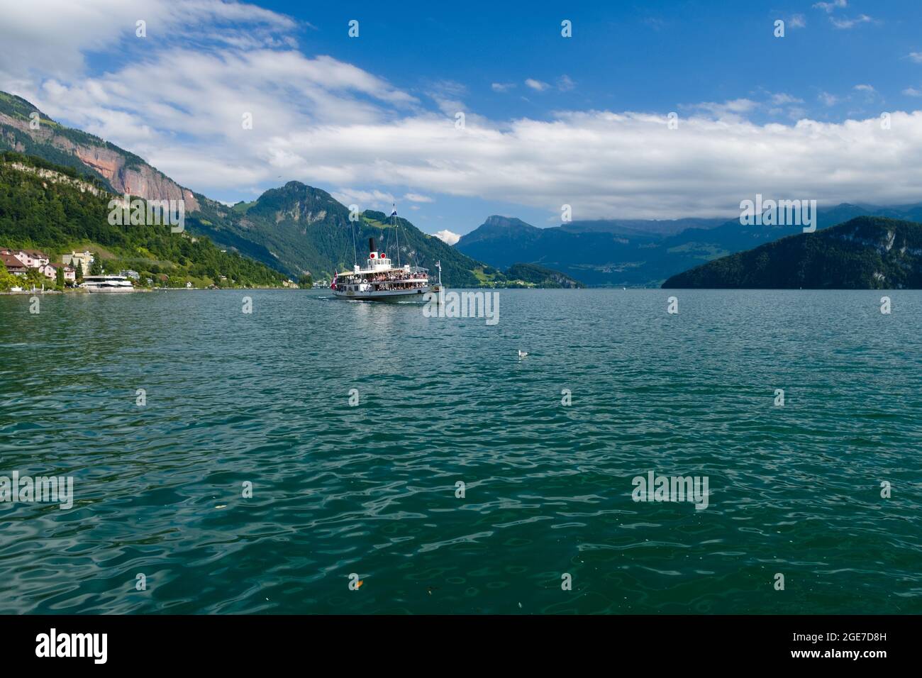 Sunny view of the old wheeled boat sailing near the village of Weggis ...