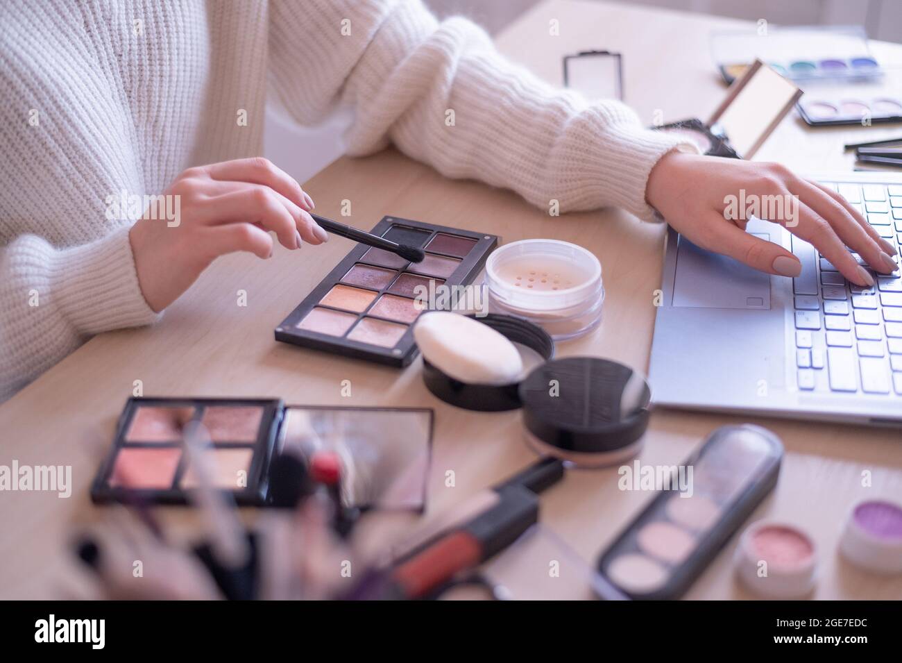 A faceless woman watches online training from a professional makeup ...