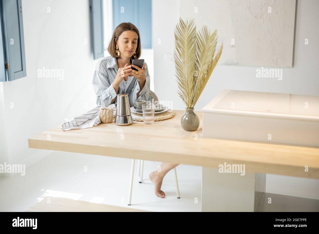 Woman with cell phone at home Stock Photo - Alamy