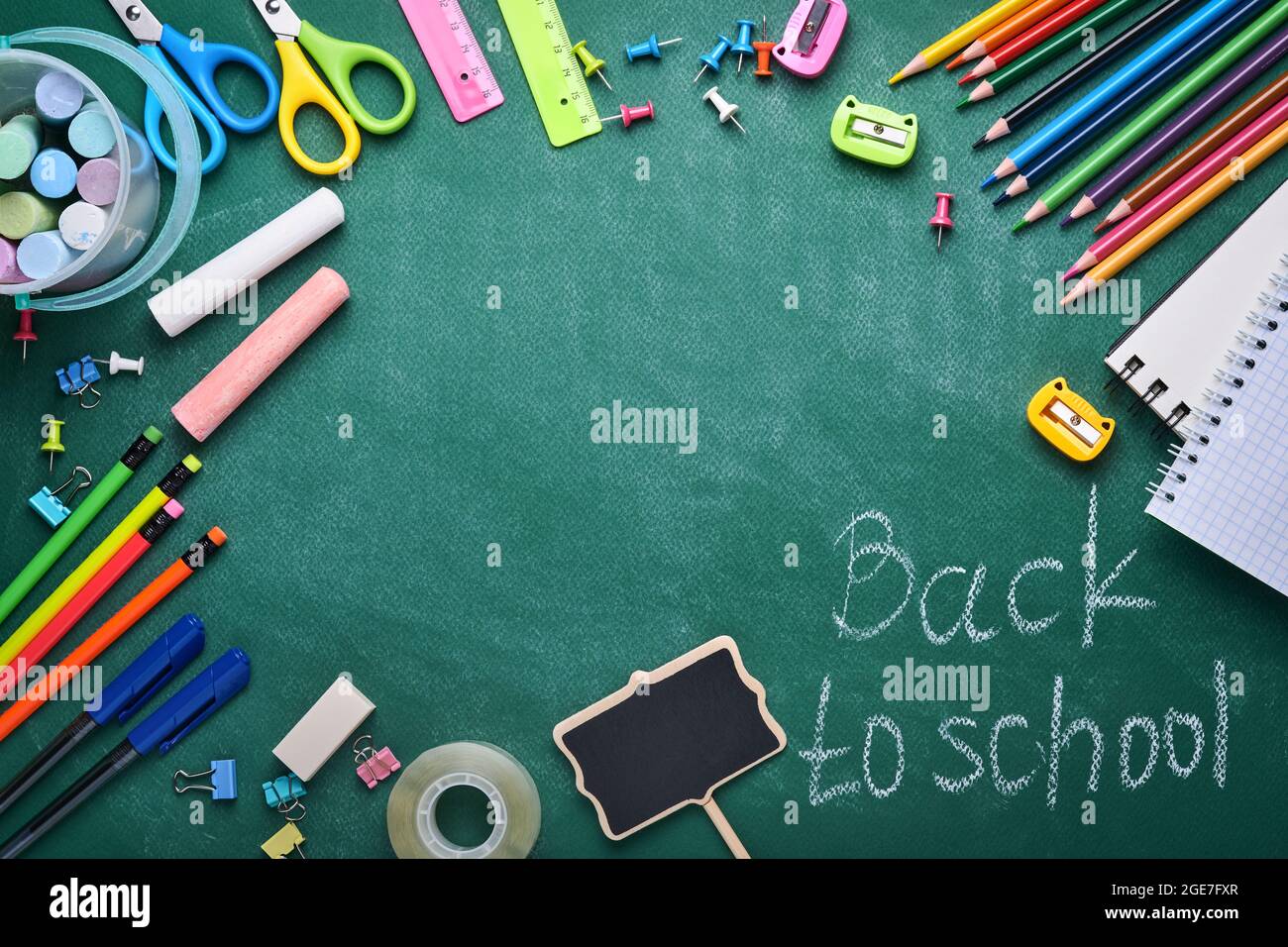 School supplies and black table lamp on green board. Concept back to ...