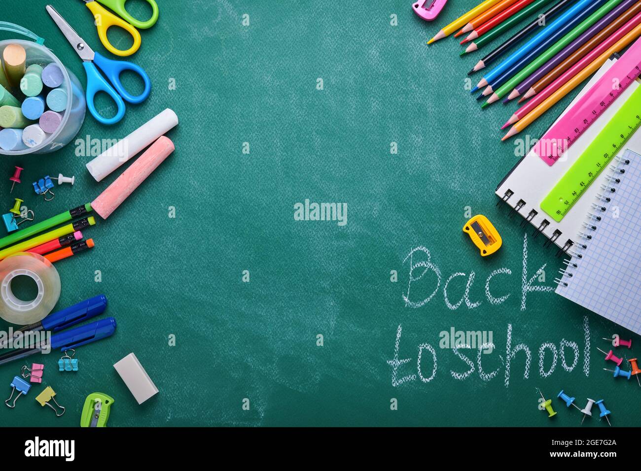 School supplies and black table lamp on green board. Concept back to ...