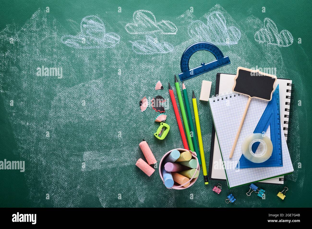 School supplies and black table lamp on green board. Concept back to ...
