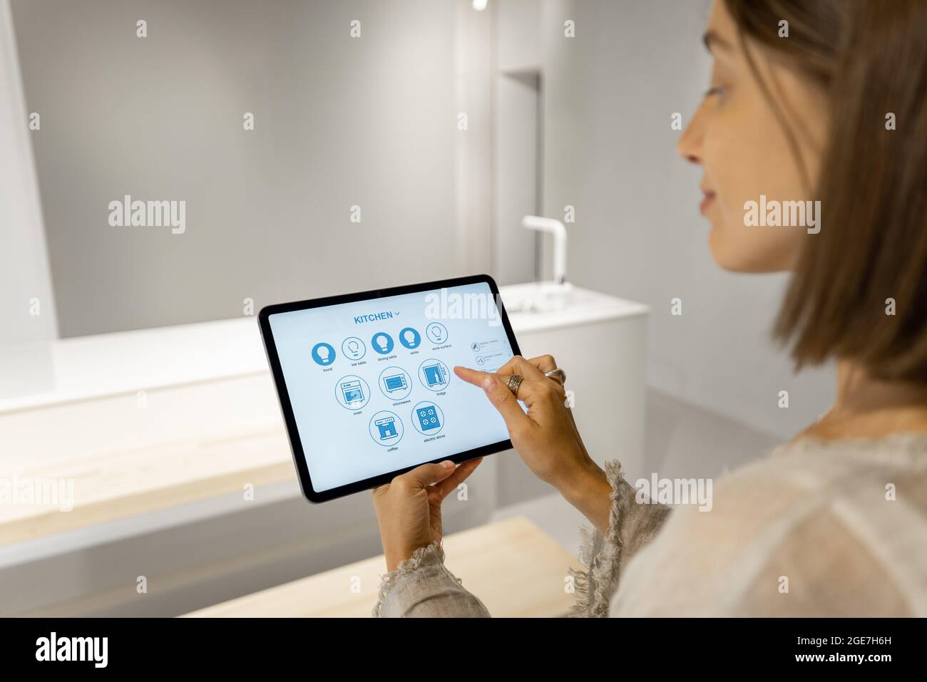 Woman controls smart kitchen appliances with mobile device Stock Photo ...