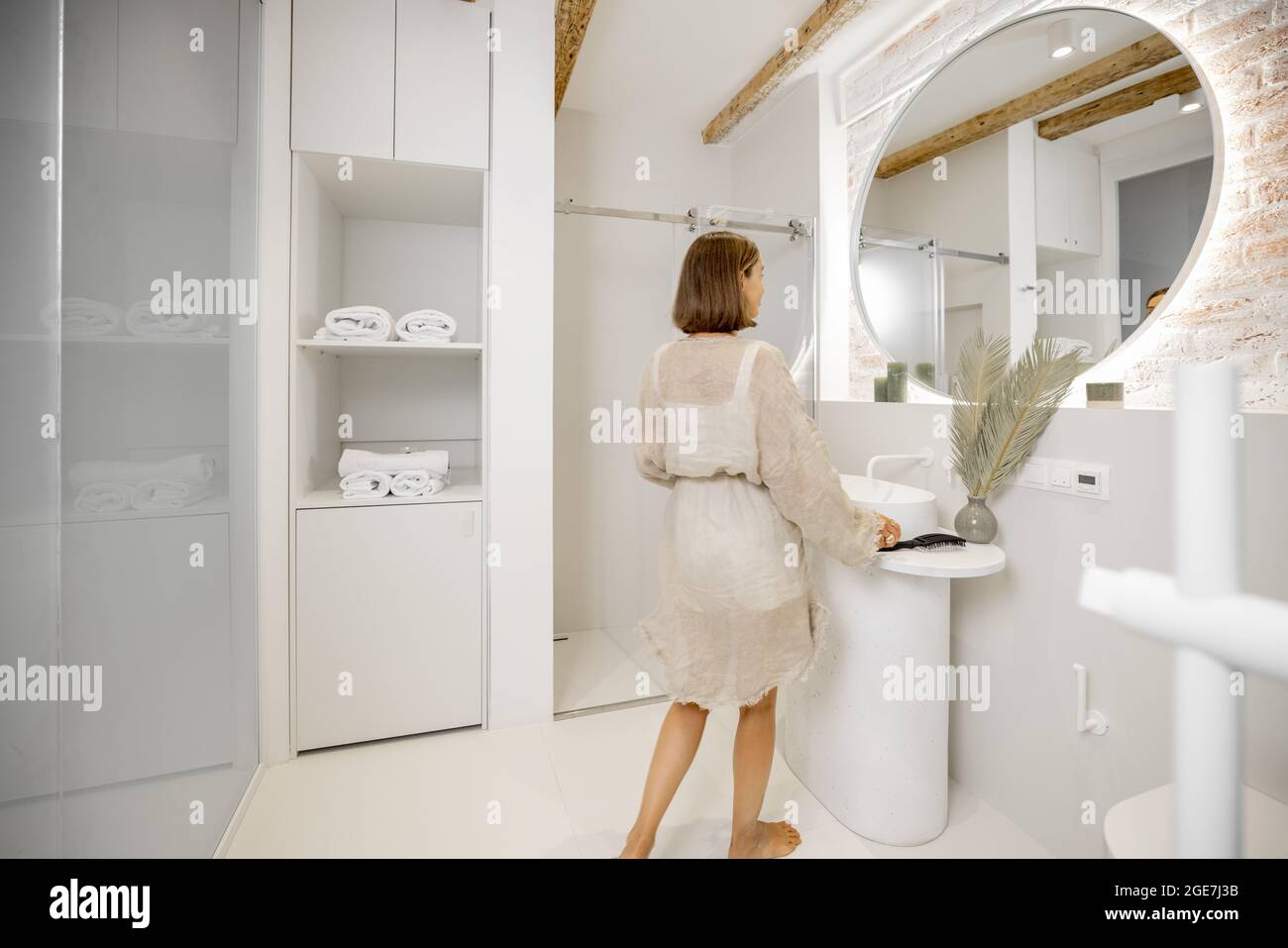 Lifestyle portrait of a woman at modern and bright bathroom interior ...