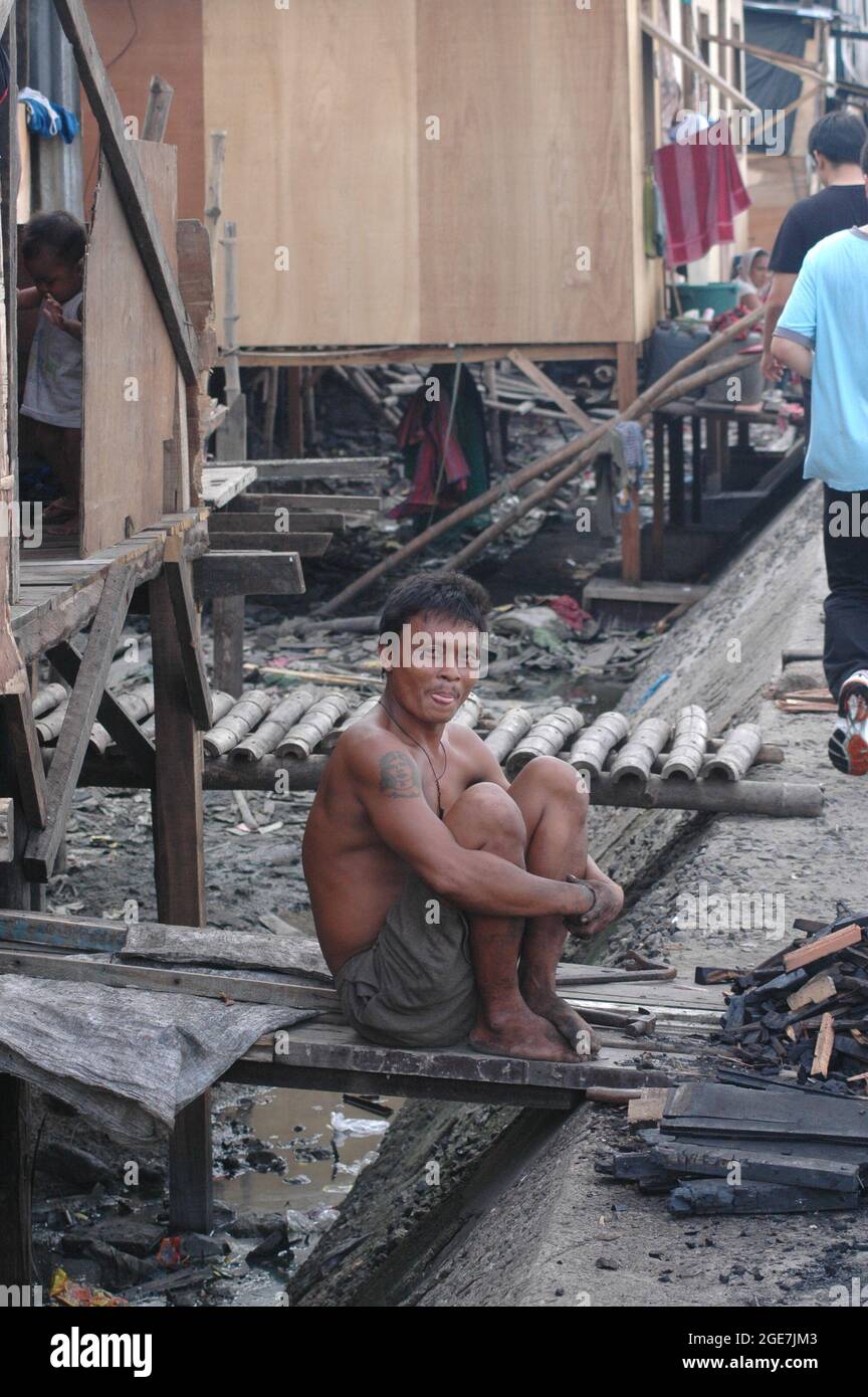 MANILA, PHILIPPINES - Oct 20, 2011: A Filipino man sitting in a village ...