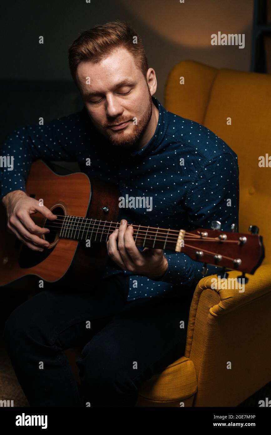 Vertical portrait of handsome guitarist singer male playing acoustic ...