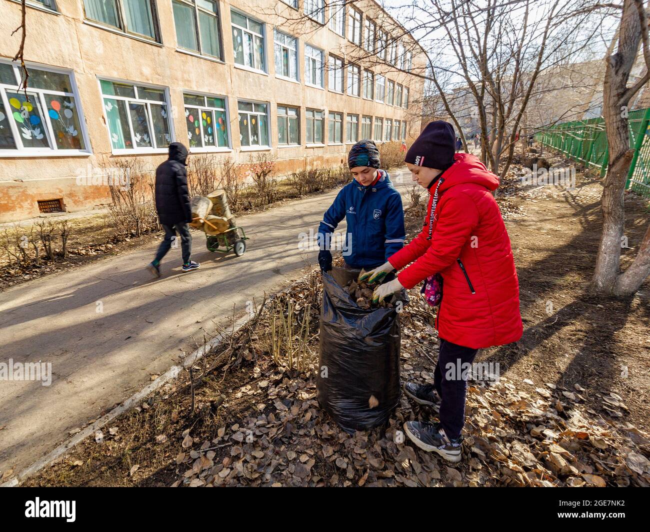 Omsk, Russia. 24 April, 2021. Schoolchildren fill a plastic bag with ...