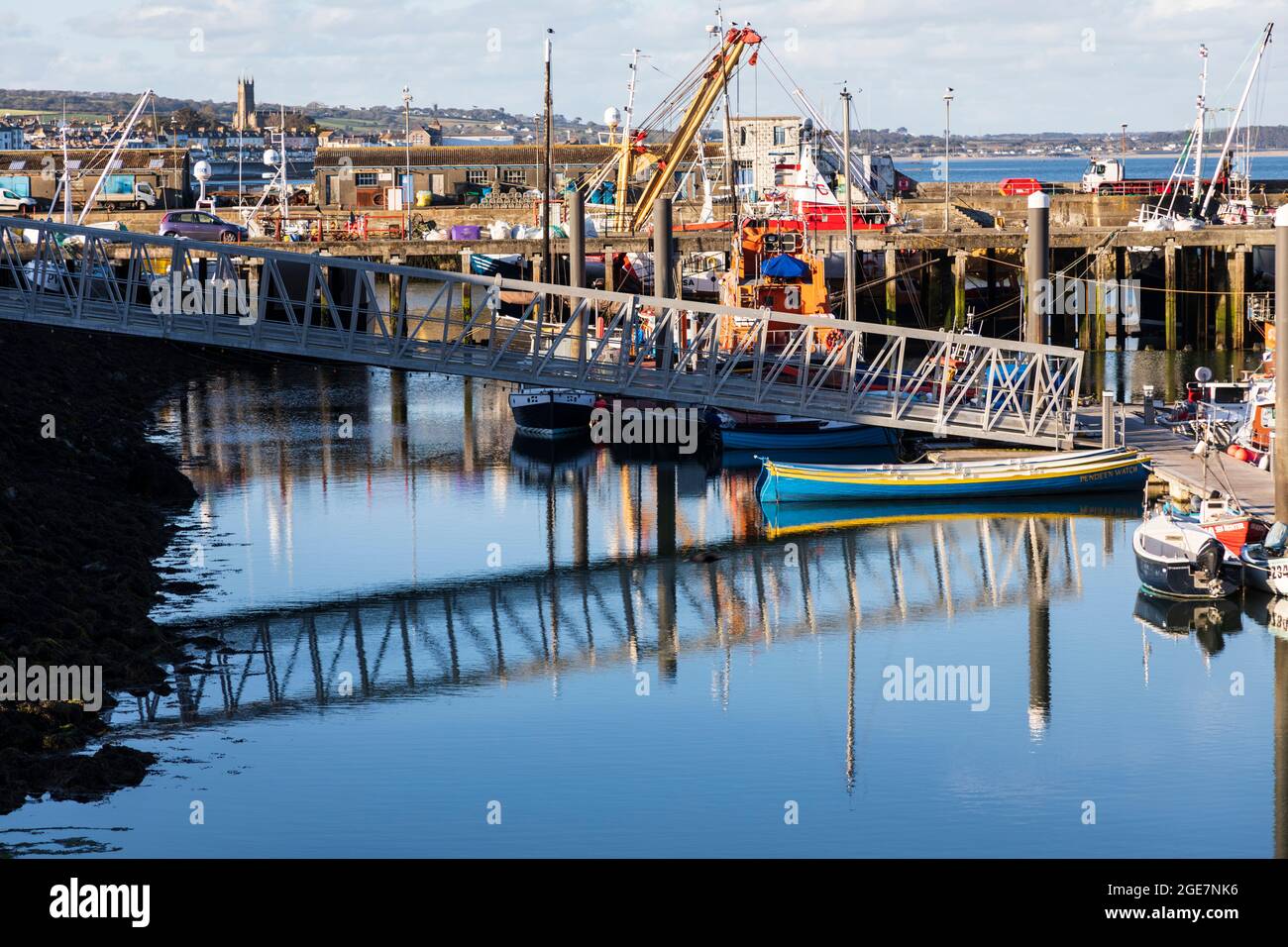 Walkway reflected in the water with floating pontoons and boats of ...