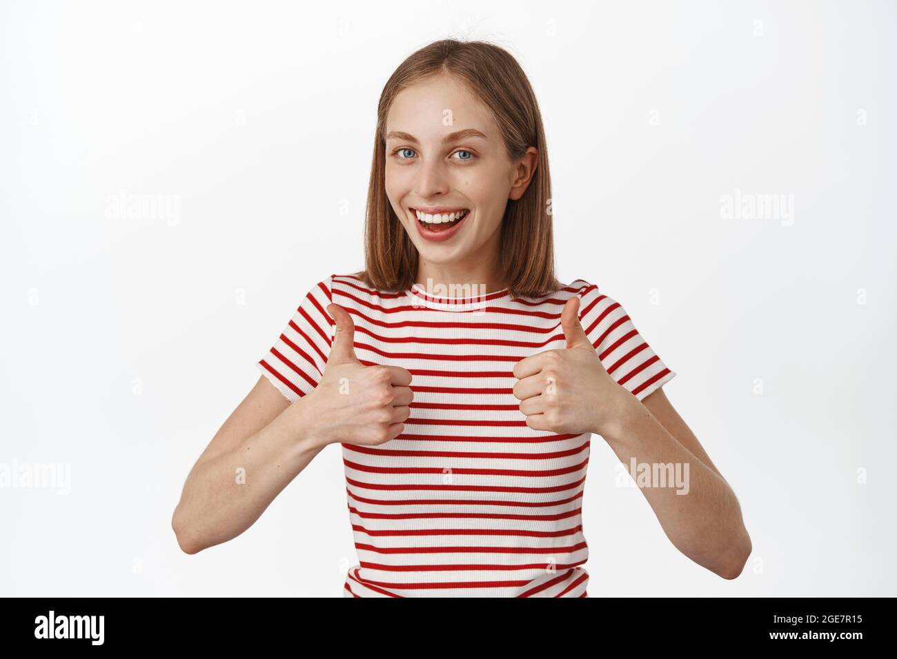 Yes, great job. Smiling confident blond girl showing thumbs up and nod ...