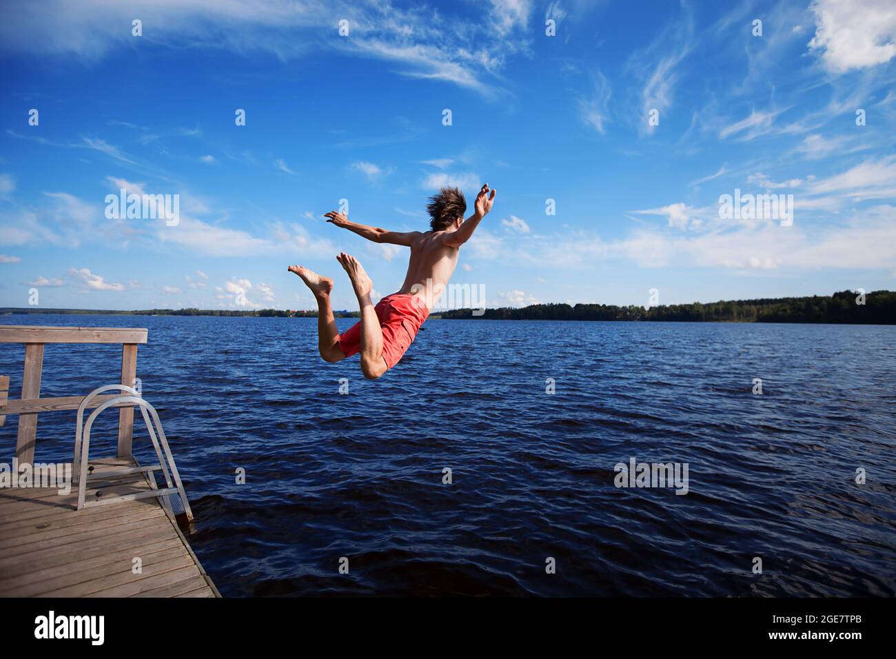 Young man jumping into water, summer time Stock Photo - Alamy